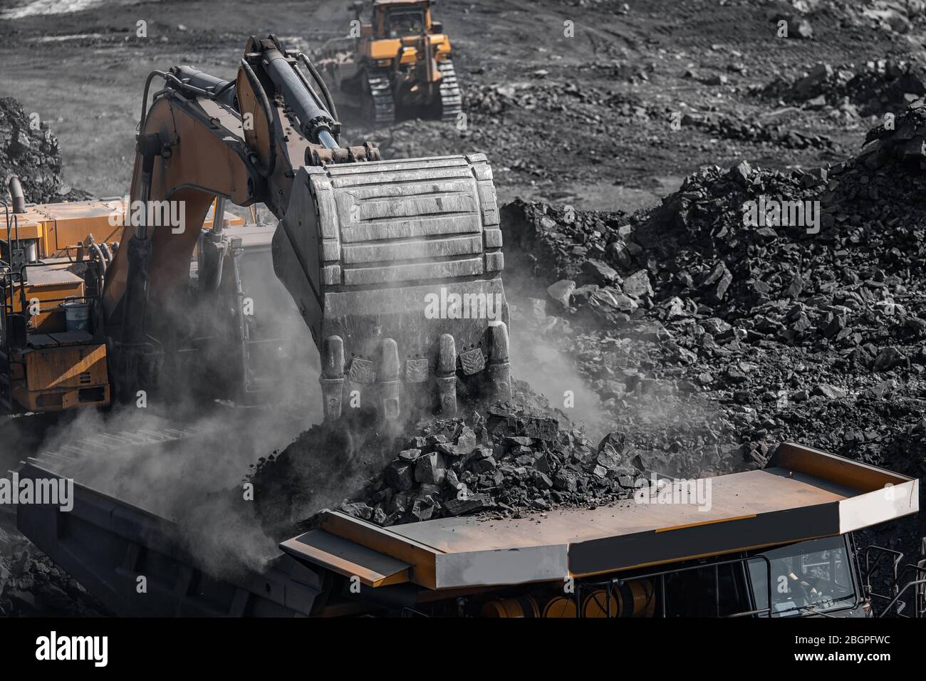 Open pit mine industry. Excavator work loading of coal into Yellow ...