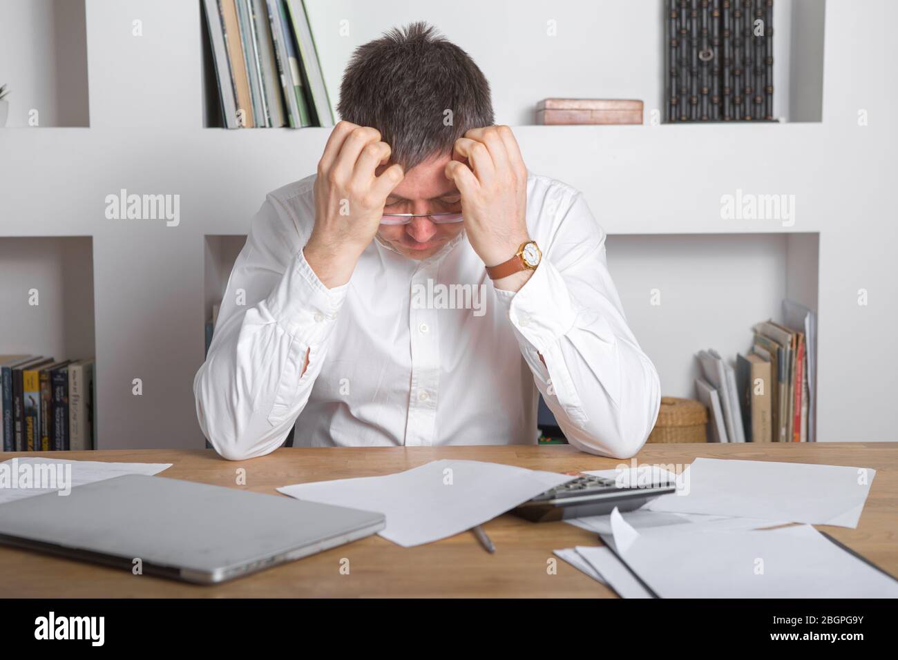 Sad manager getting notice of dismissal, sitting at workplace with ...