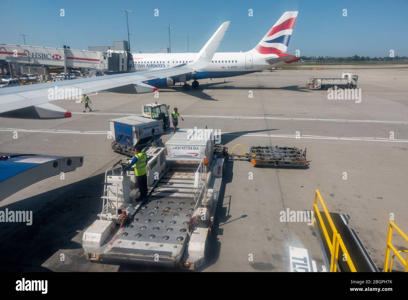 Baggage being loaded onto a BA Airbus A320 at London Heathrow Airport ...