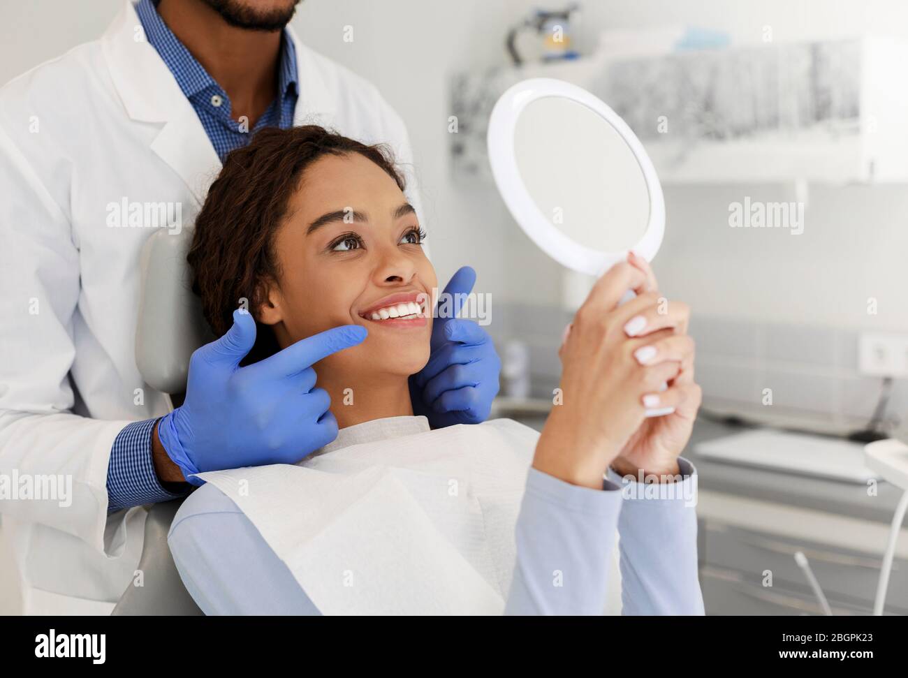 Attractive lady checking her beautiful smile in mirror Stock Photo - Alamy