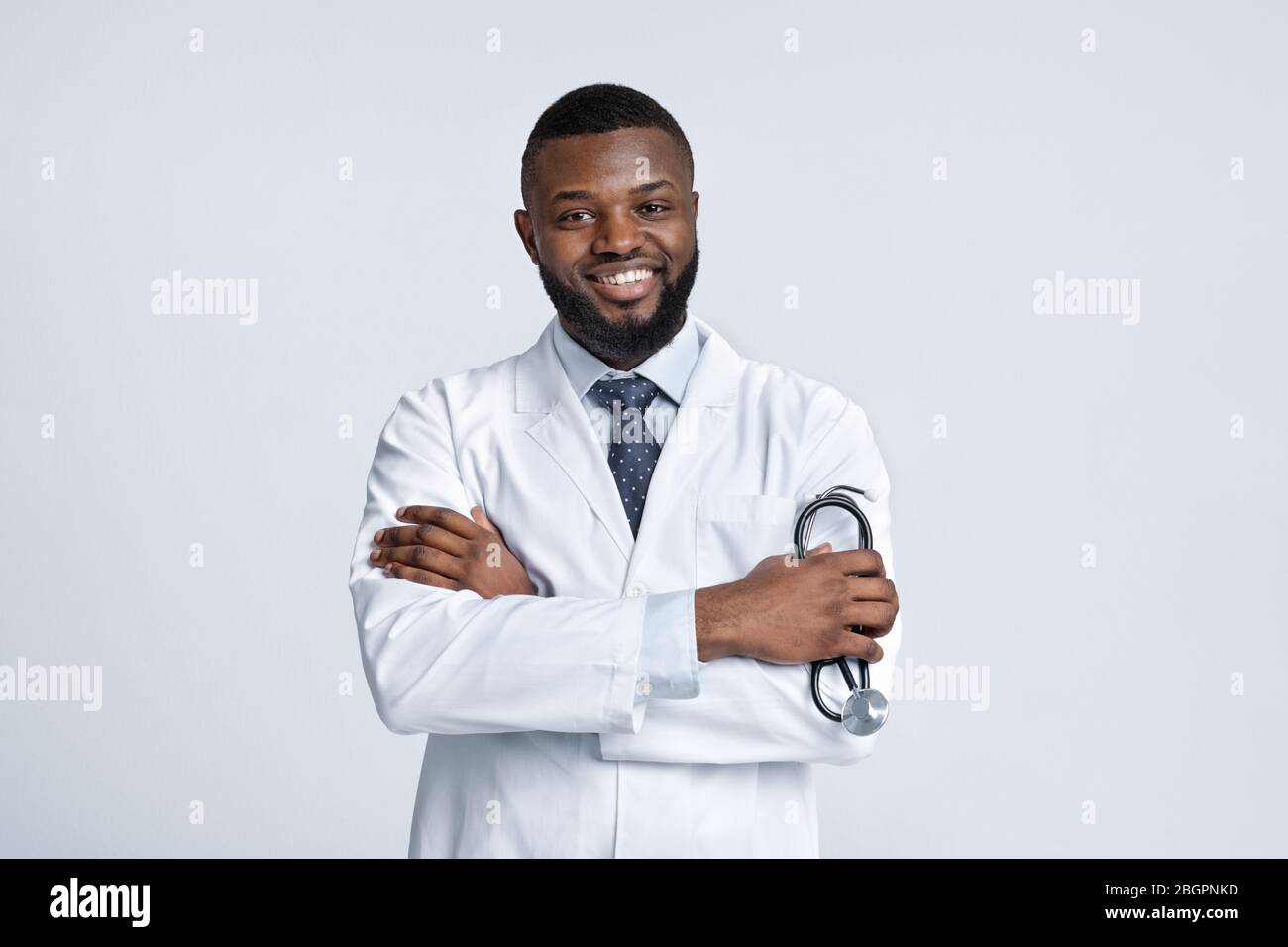 Confident smiling african medical doctor over white studio background ...