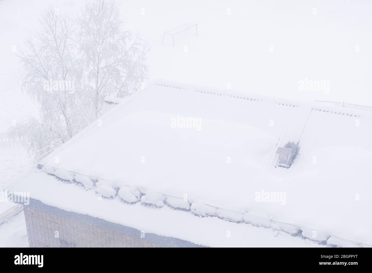 Brick house with snow on the roof in winter. View from the window Stock ...