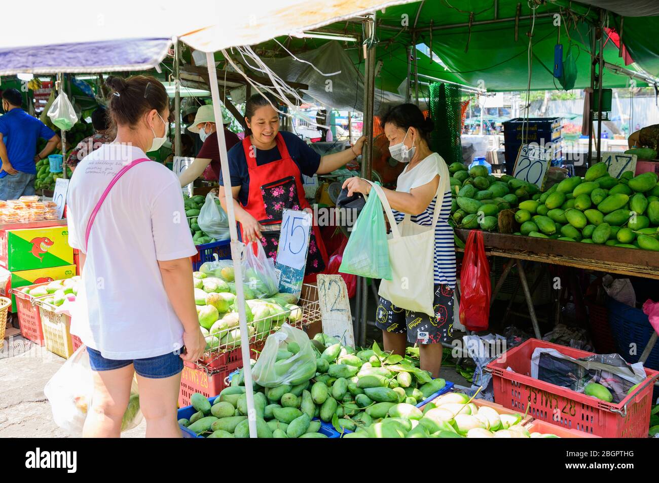 Thai people shopping at local wholesale fruit market with a mask on ...
