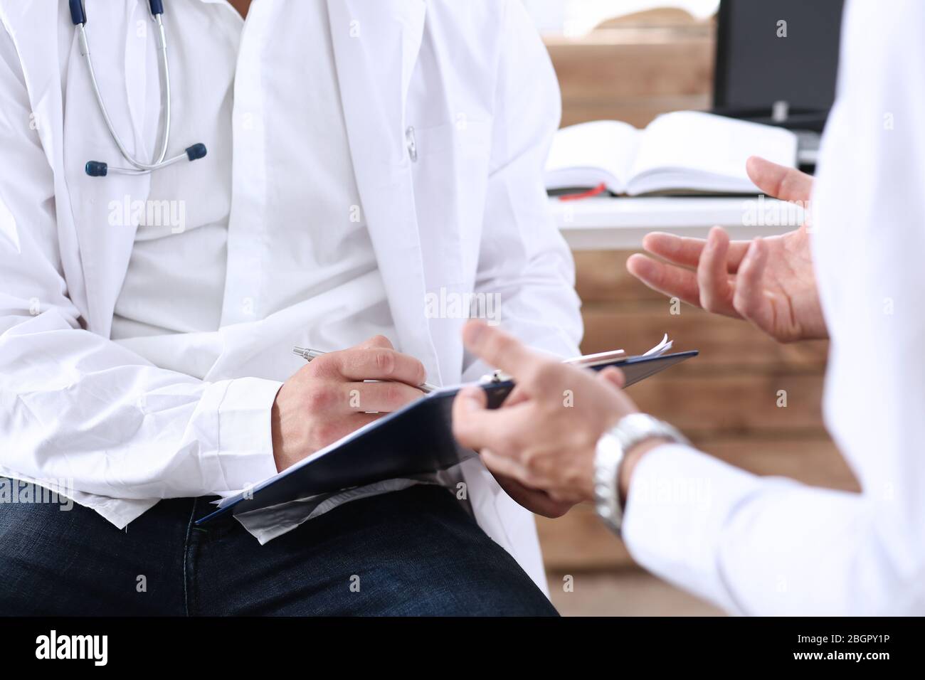 Male medicine doctor with clipboard pad in hands examine patient Stock ...