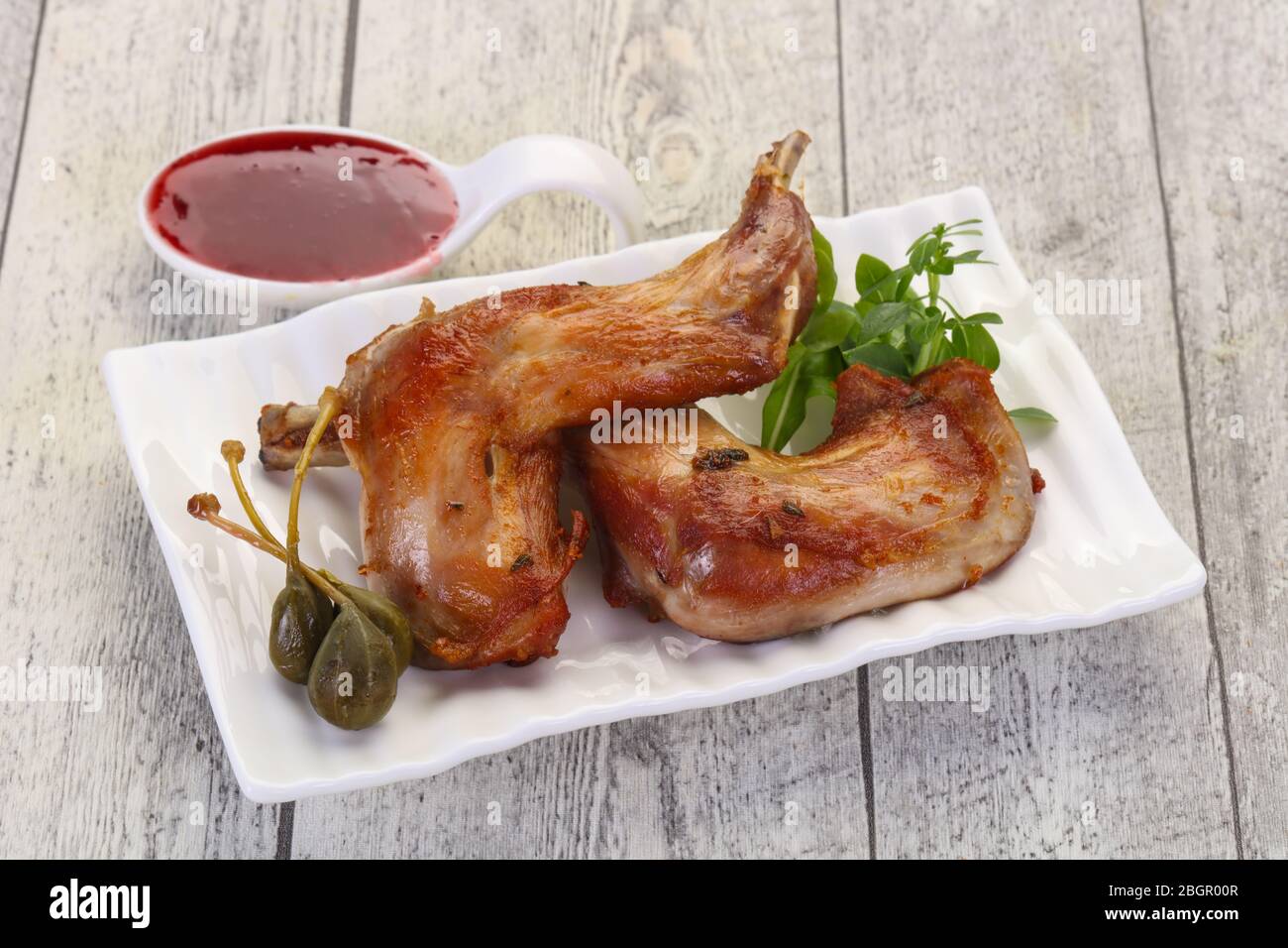 Roasted rabbit legs with cowberry sauce Stock Photo - Alamy