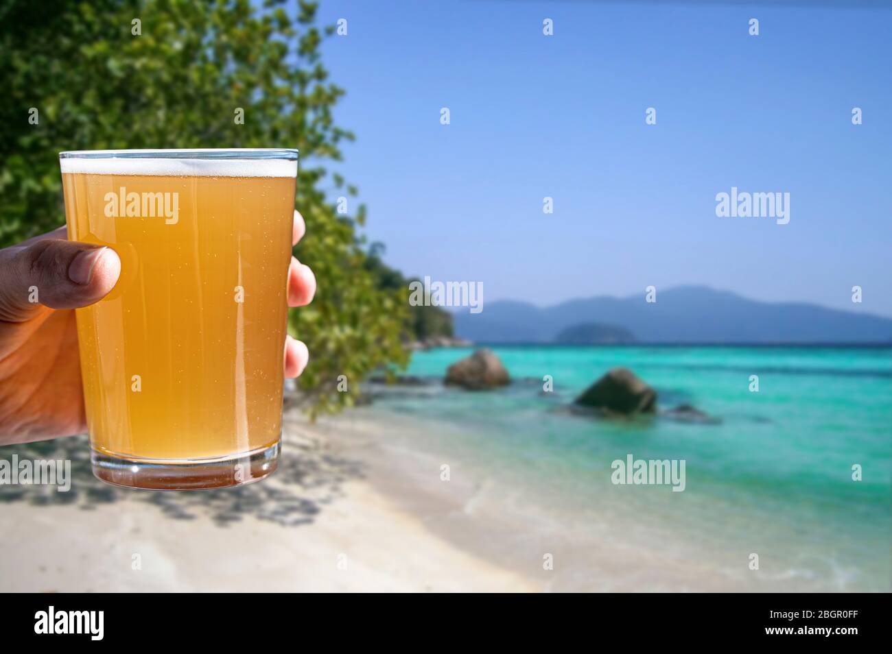 Hand holding glass of beer on beach background. Vacation concept Stock ...
