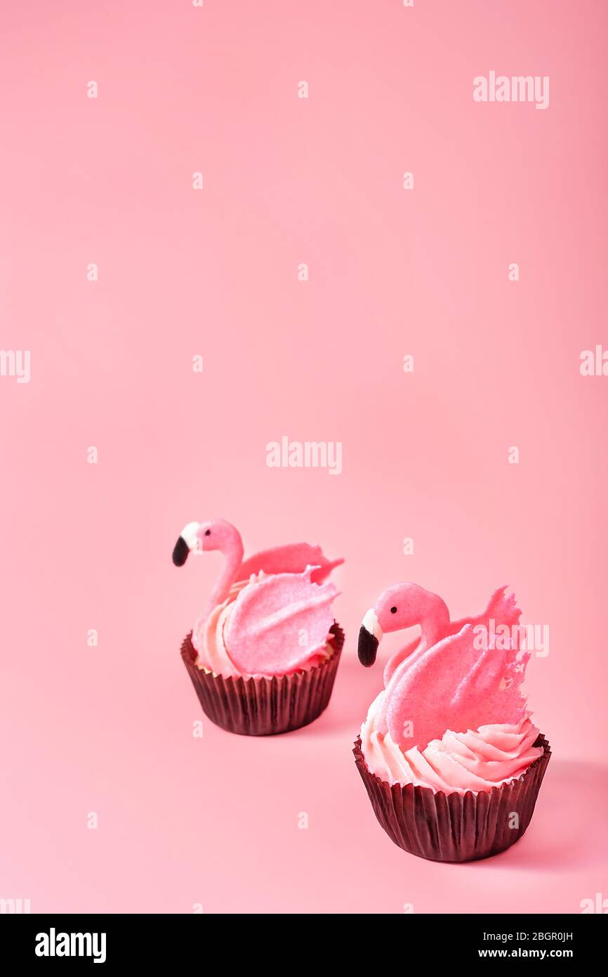 Two pink flamingo cupcakes on pastel pink background. Happy birthday ...