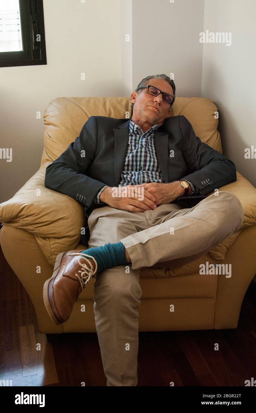 Hispanic man sleeping on chair Stock Photo - Alamy