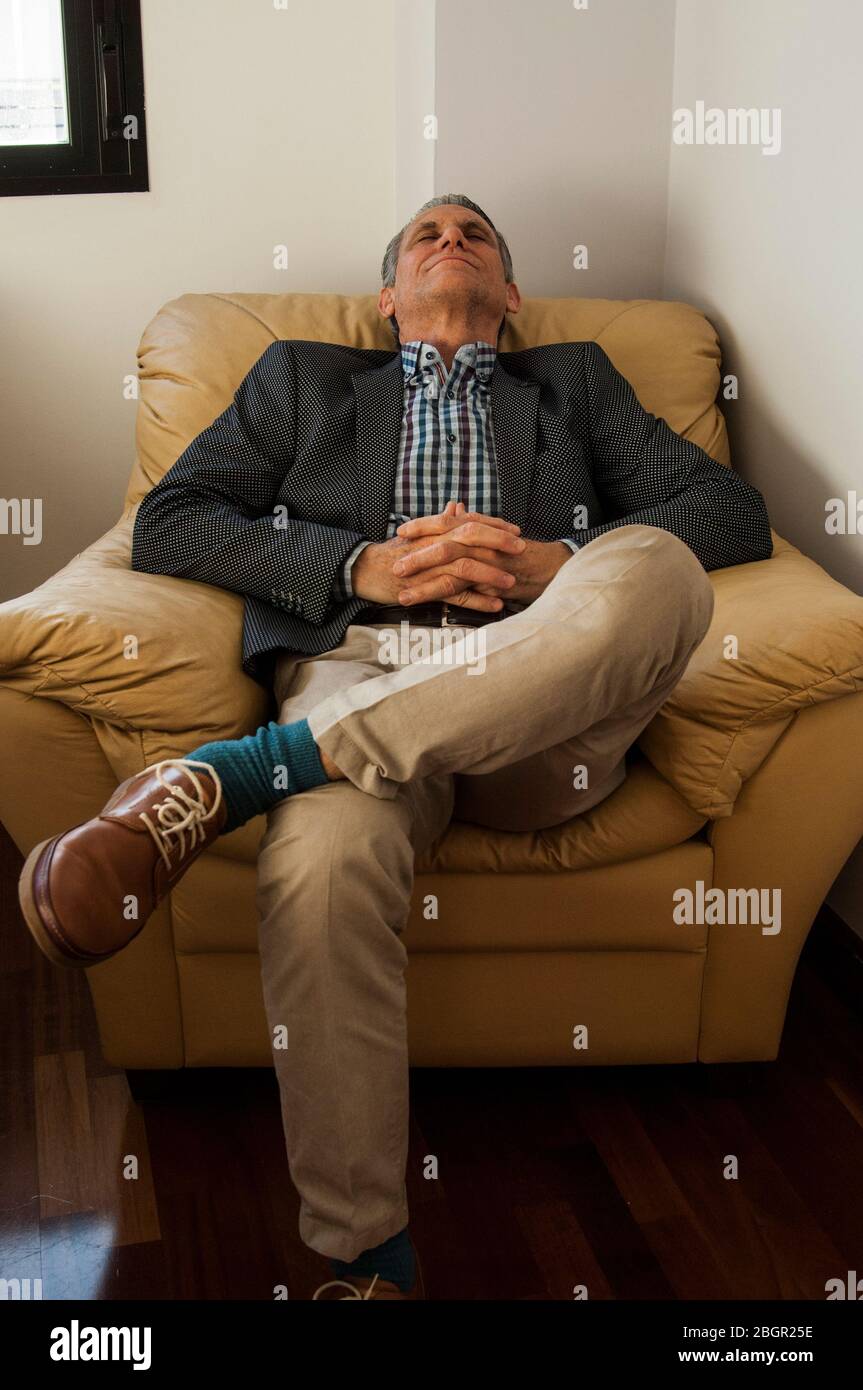 Hispanic man sleeping on chair Stock Photo - Alamy