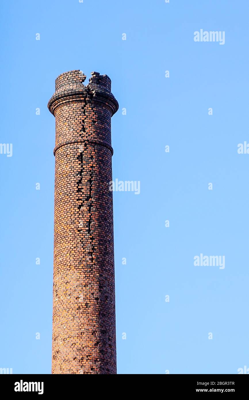 industrial heritage, dangerously crumbled and cracked red brick chimney ...