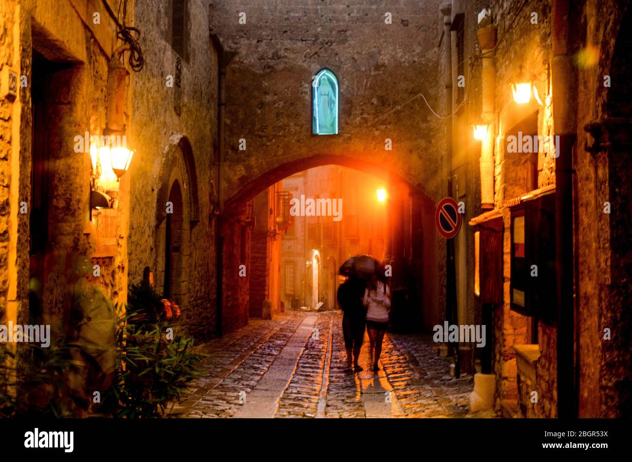 Night with windy mist and rain on a street in the ancient village of ...