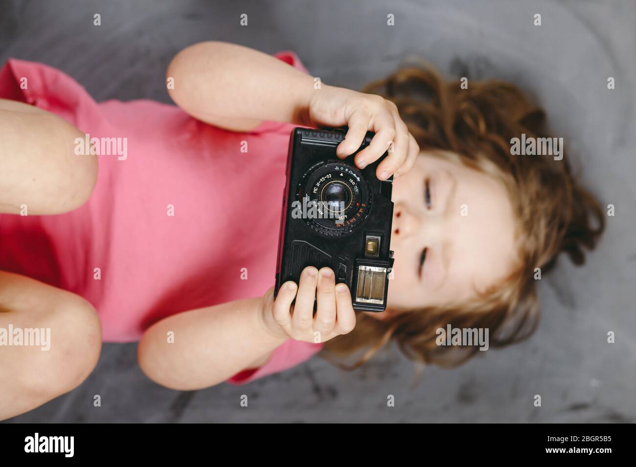 Little girl photographer with camera smiling and take a picture. Top ...
