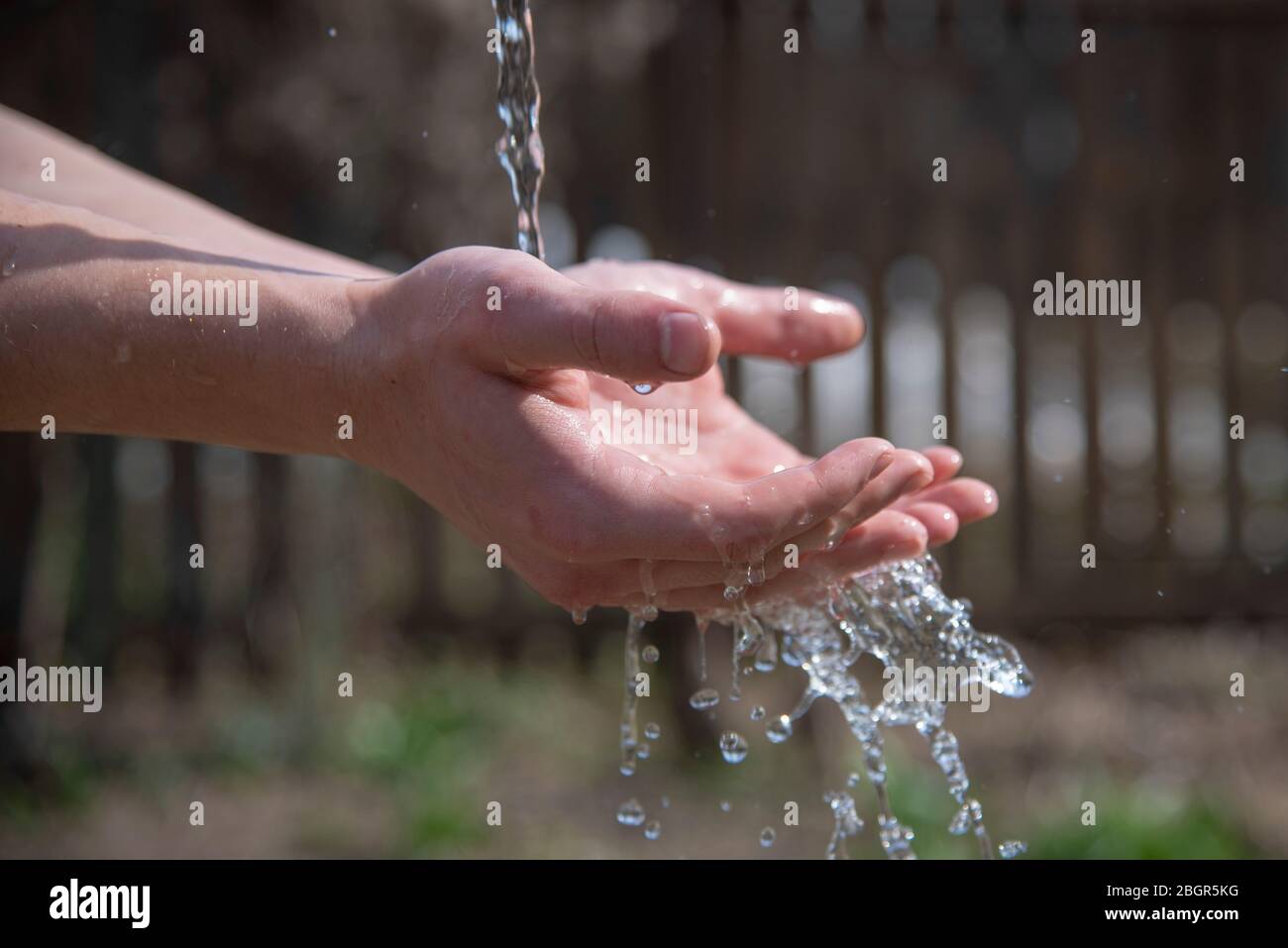 male hands under a stream of water Stock Photo - Alamy