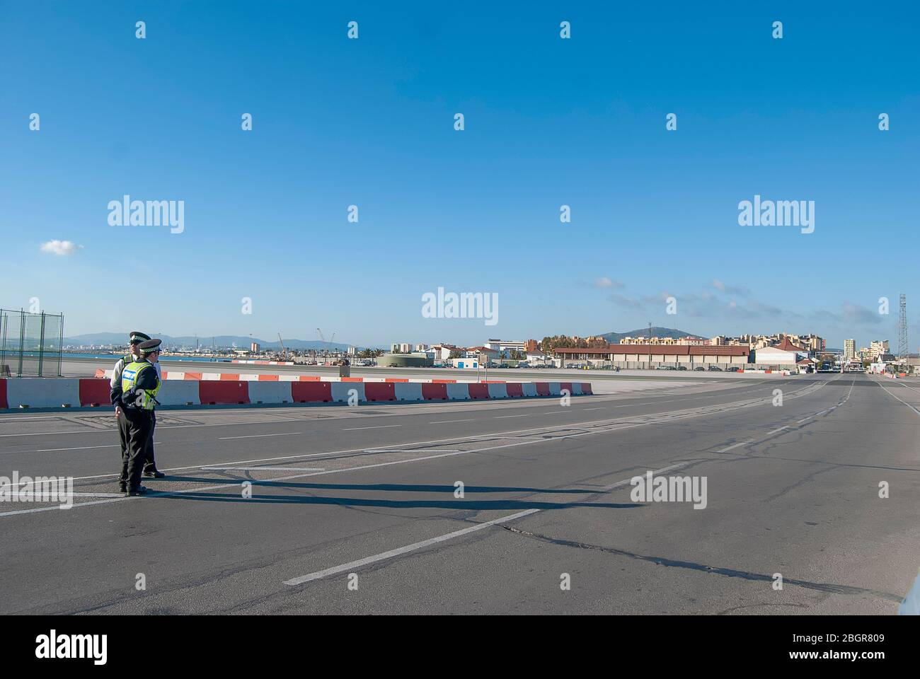 Police officers blocking the road crossing the runway of Gibraltar ...