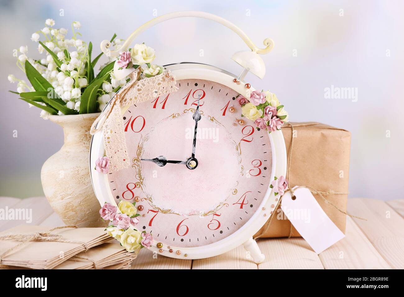Beautiful vintage alarm clock with flowers on light background Stock ...