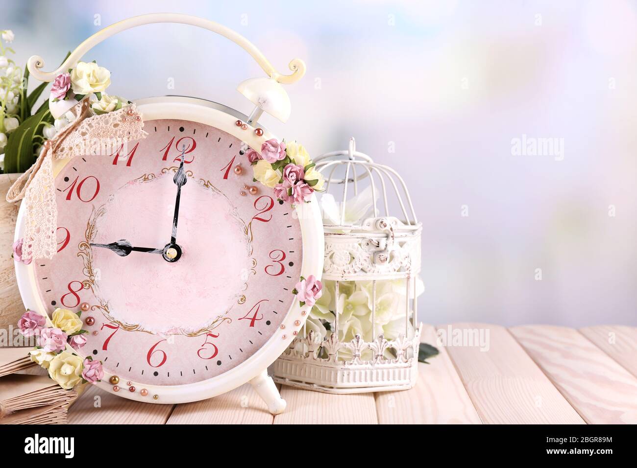 Beautiful vintage alarm clock with flowers on light background Stock ...