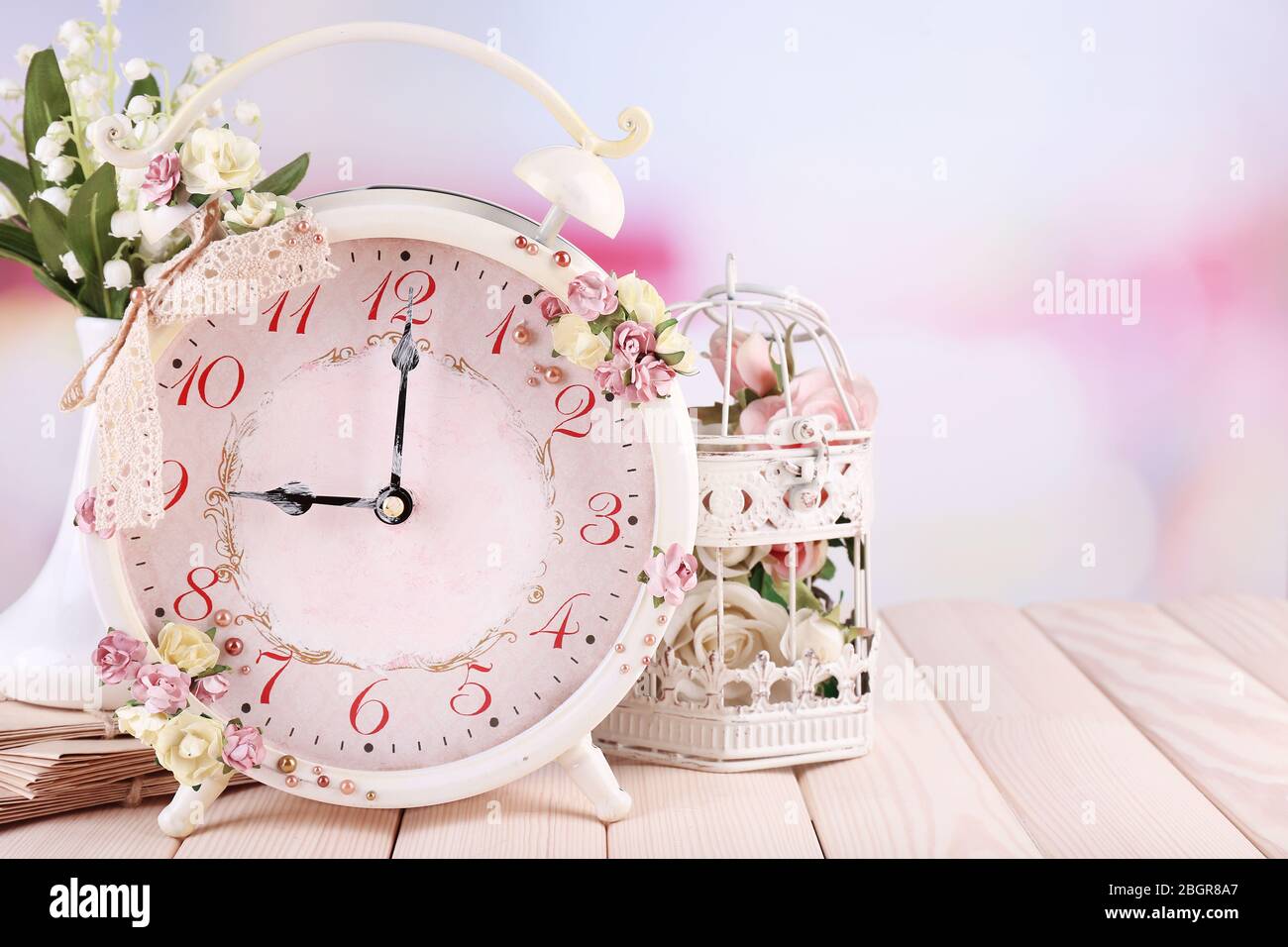 Beautiful vintage alarm clock with flowers on light background Stock ...
