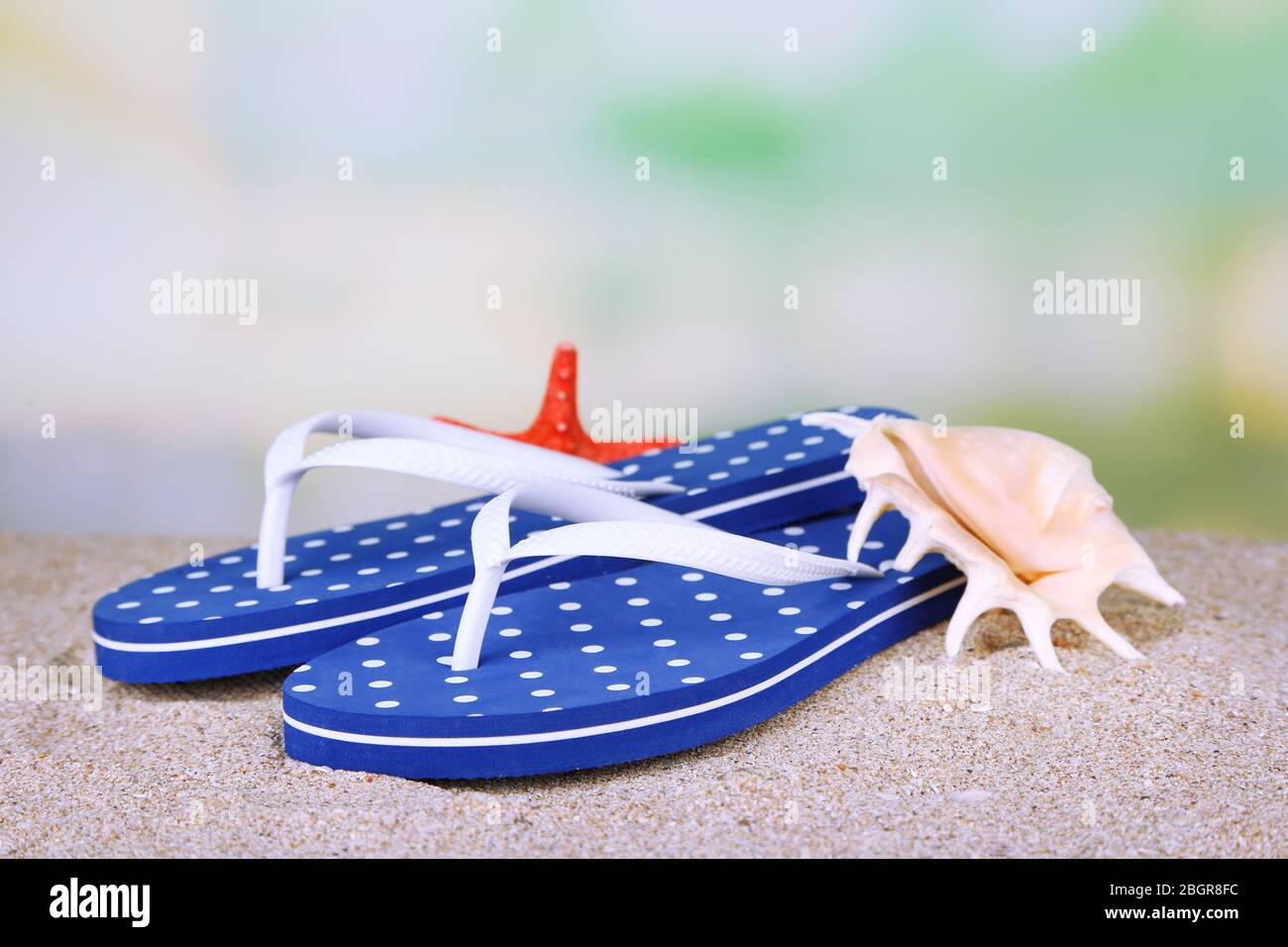 Color flip-flops on sand, on nature background Stock Photo - Alamy