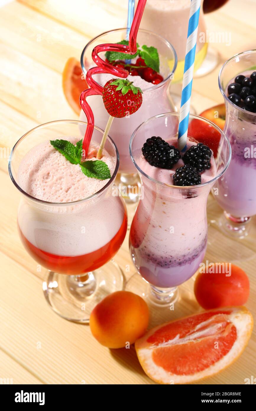Delicious milkshakes on wooden table, close-up Stock Photo - Alamy