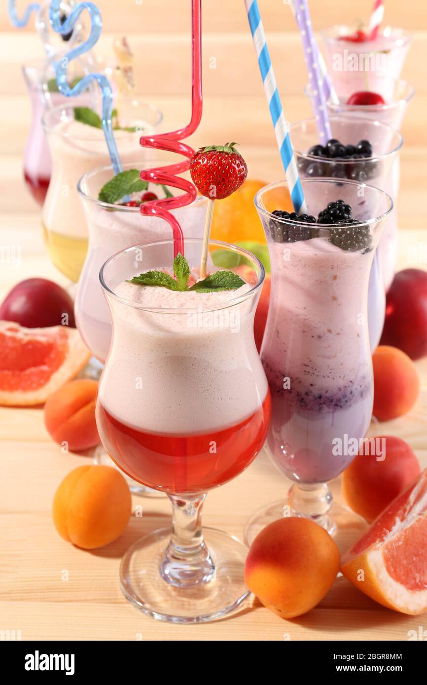 Delicious milkshakes on wooden table, close-up Stock Photo - Alamy