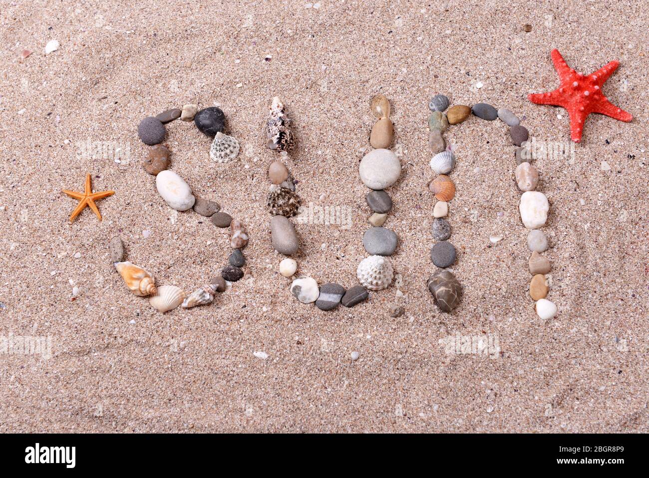 Word sun made from sea shells and stones on sand Stock Photo - Alamy