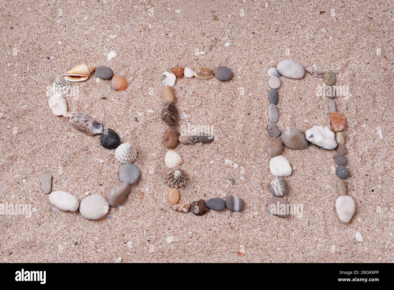 Word sea made from sea shells and stones on sand Stock Photo - Alamy