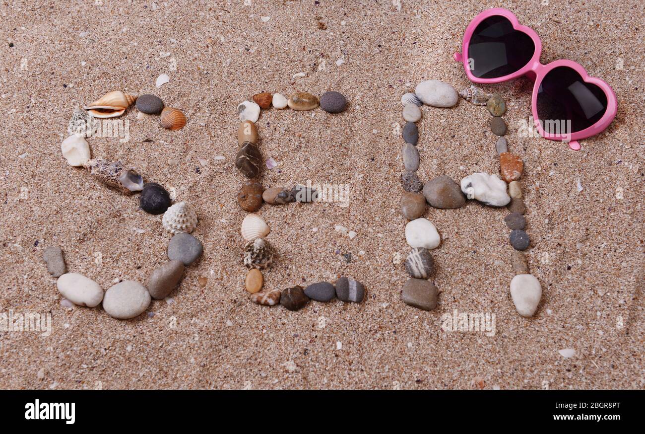Word sea made from sea shells and stones on sand Stock Photo - Alamy