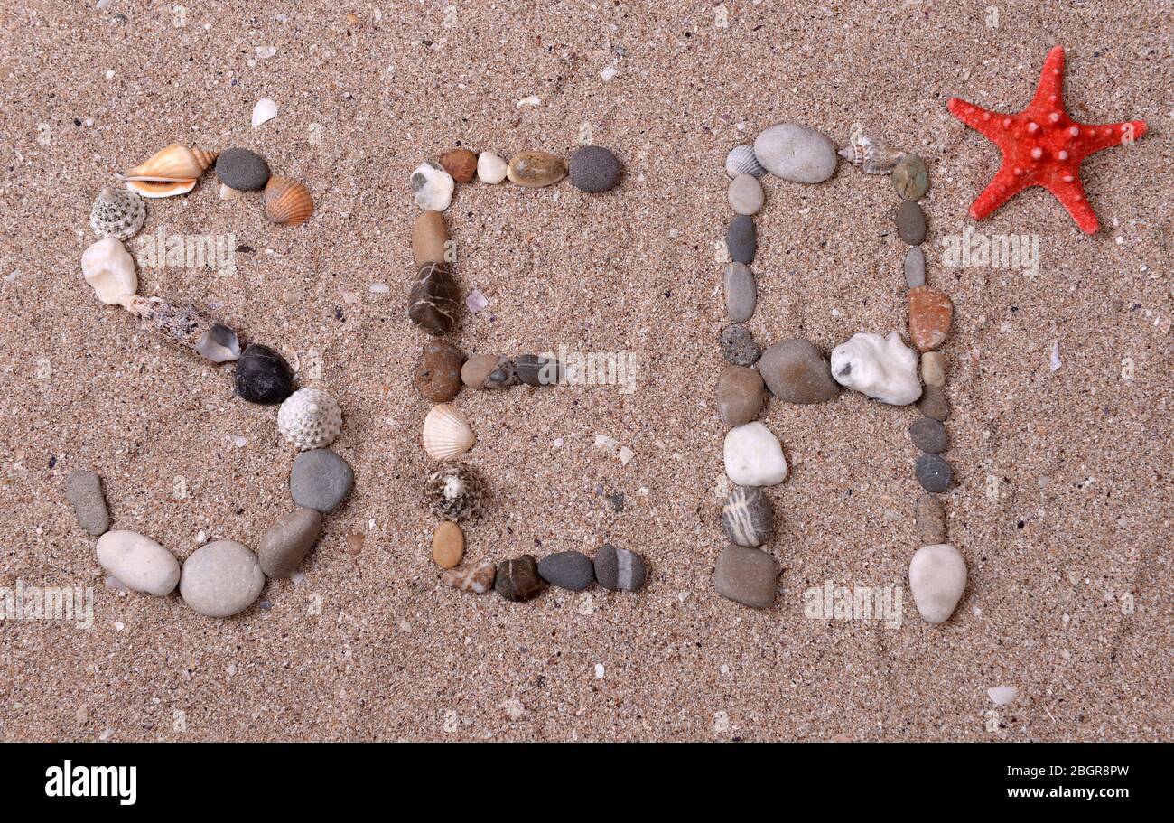Word sea made from sea shells and stones on sand Stock Photo - Alamy