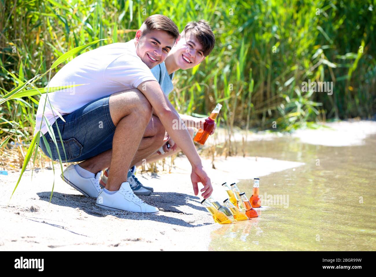 Handsome young men on beach Stock Photo - Alamy