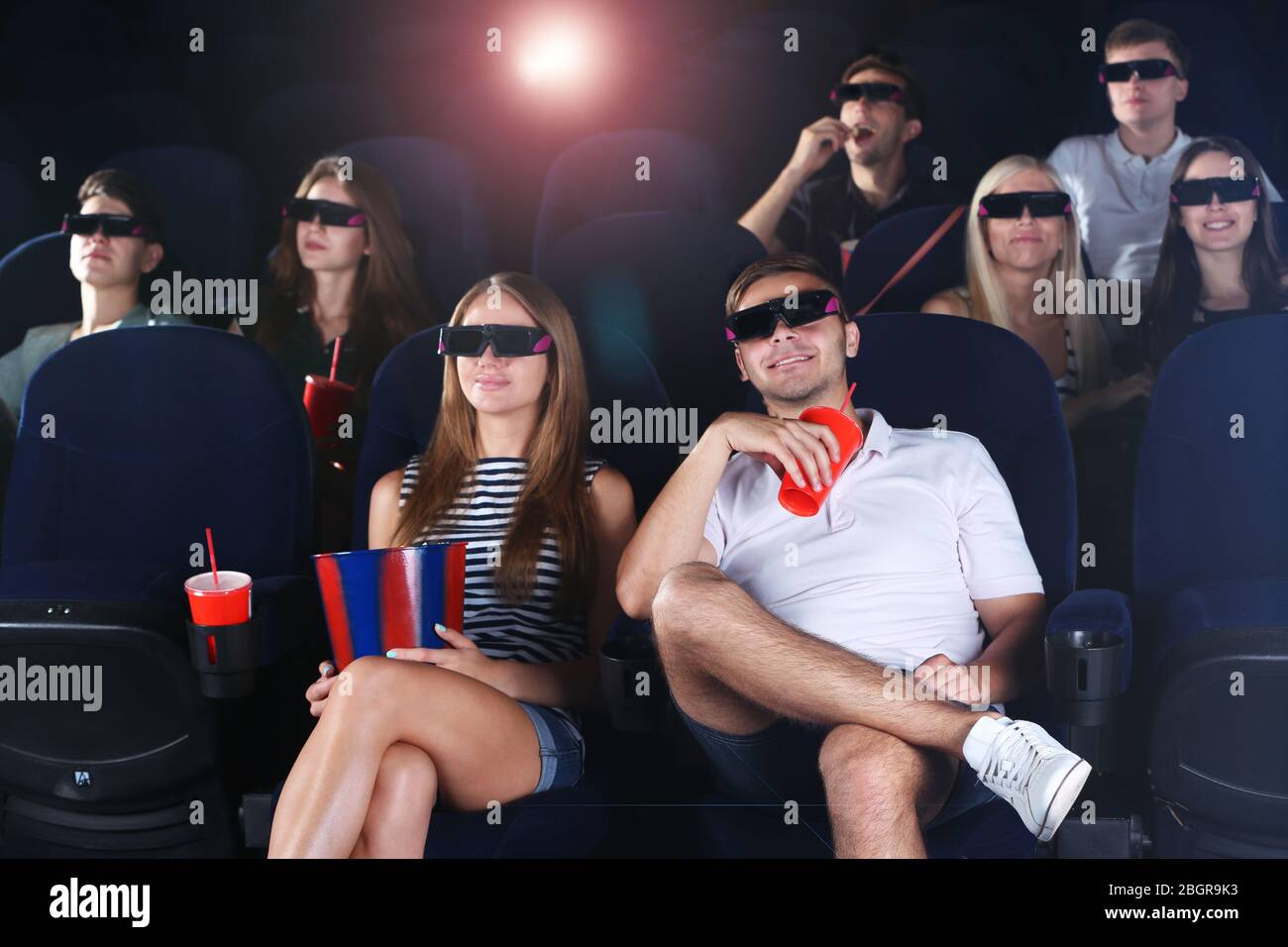 Young people watching movie in cinema Stock Photo - Alamy