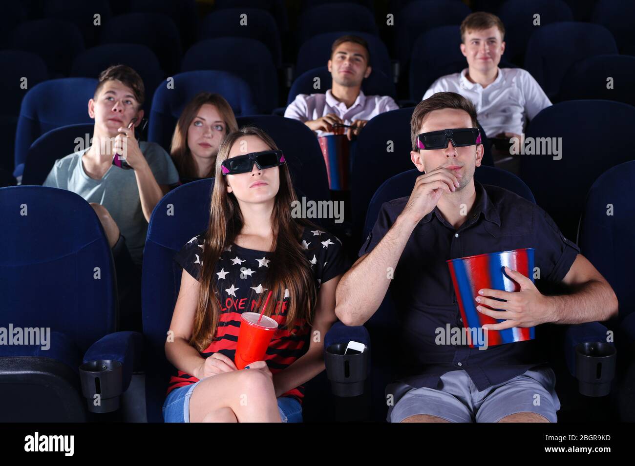 Young people watching movie in cinema Stock Photo - Alamy