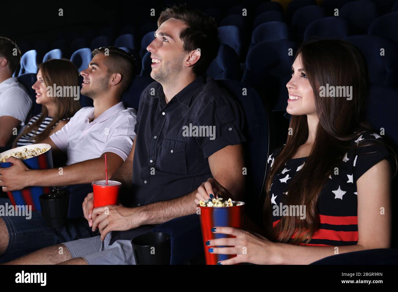 Young people watching movie in cinema Stock Photo - Alamy