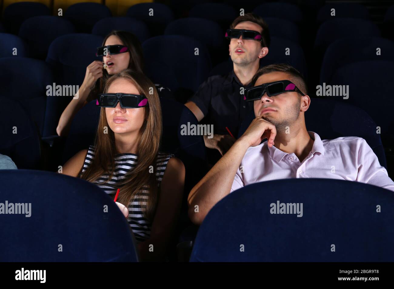 Young people watching movie in cinema Stock Photo - Alamy