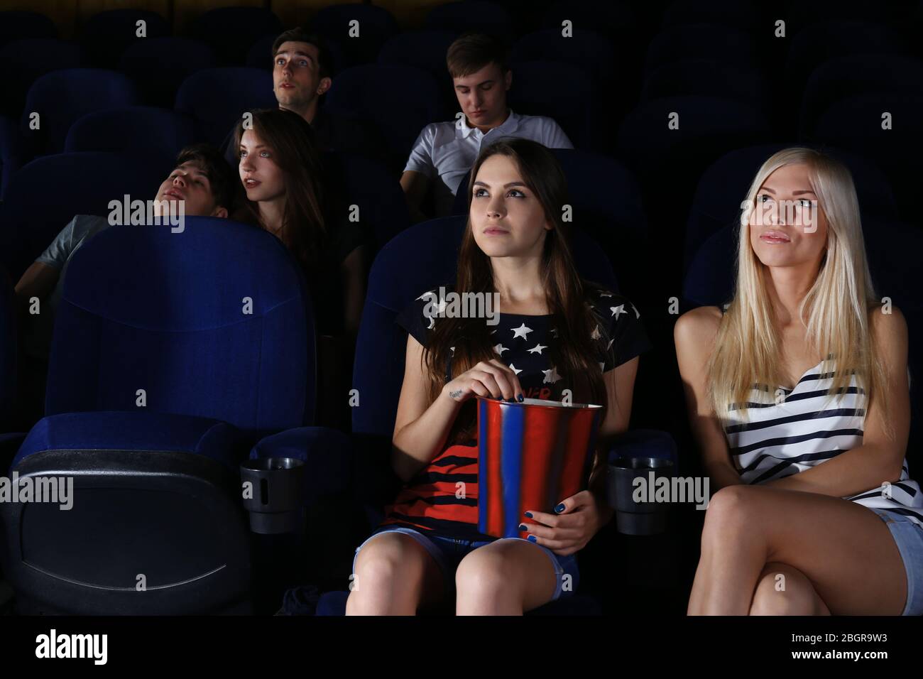 Young people watching movie in cinema Stock Photo - Alamy