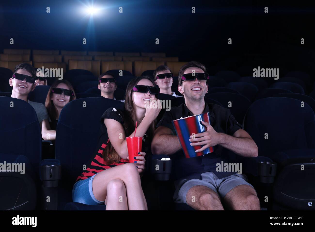 Young people watching movie in cinema Stock Photo - Alamy