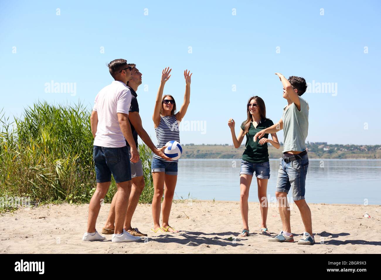 Friends playing beach volleyball together hi-res stock photography and ...