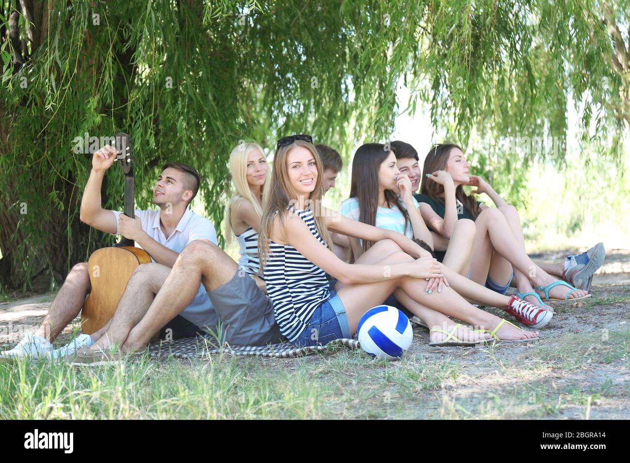 Group of friends having rest at park Stock Photo - Alamy