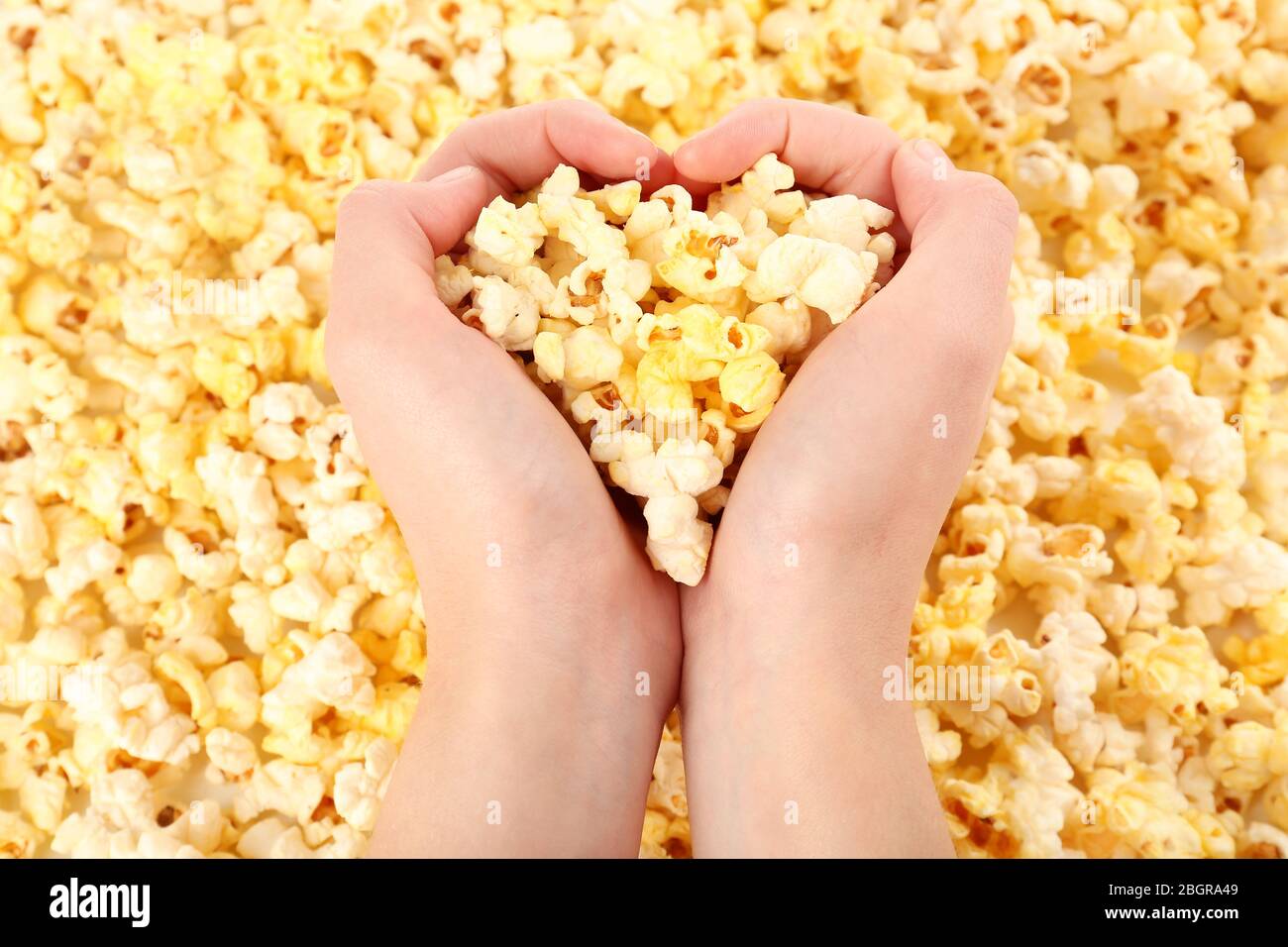 Popcorn in hands, close-up Stock Photo - Alamy