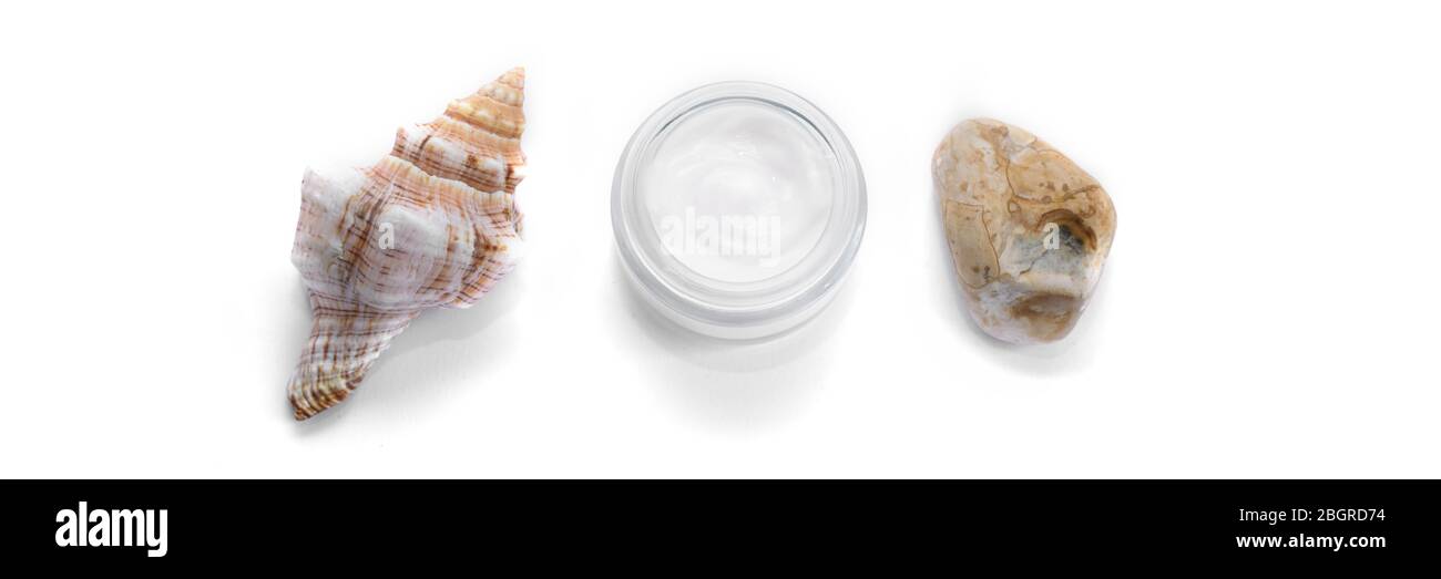 Opened facial cream and sea shell and stone on the isolated white ...
