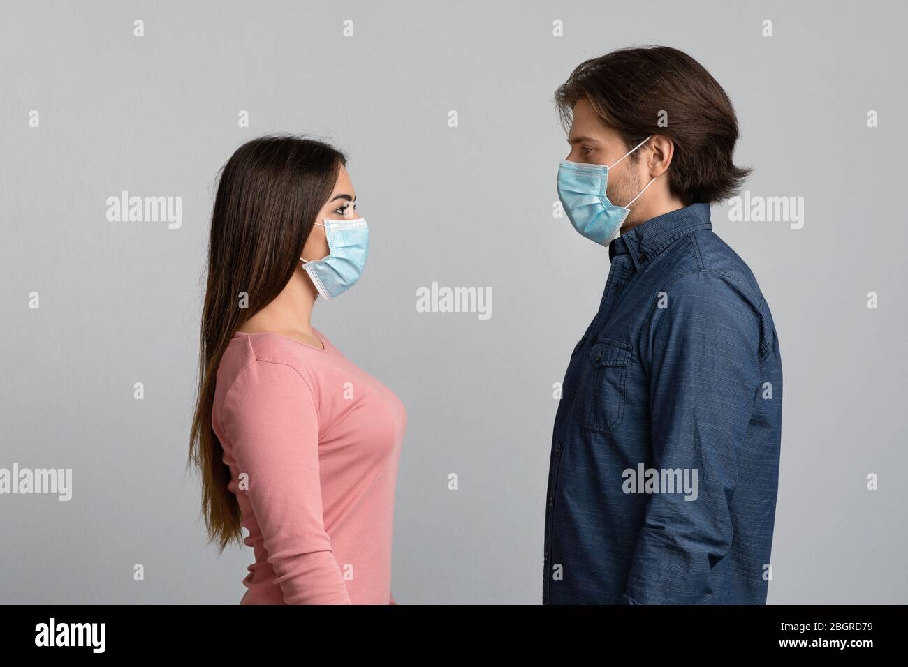 Social Distancing. Young Couple Wearing Medical Masks Standing Face To ...