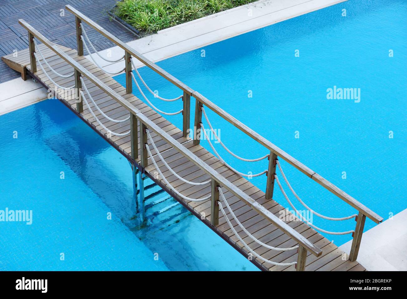 Bridge across hotel swimming pool Stock Photo - Alamy