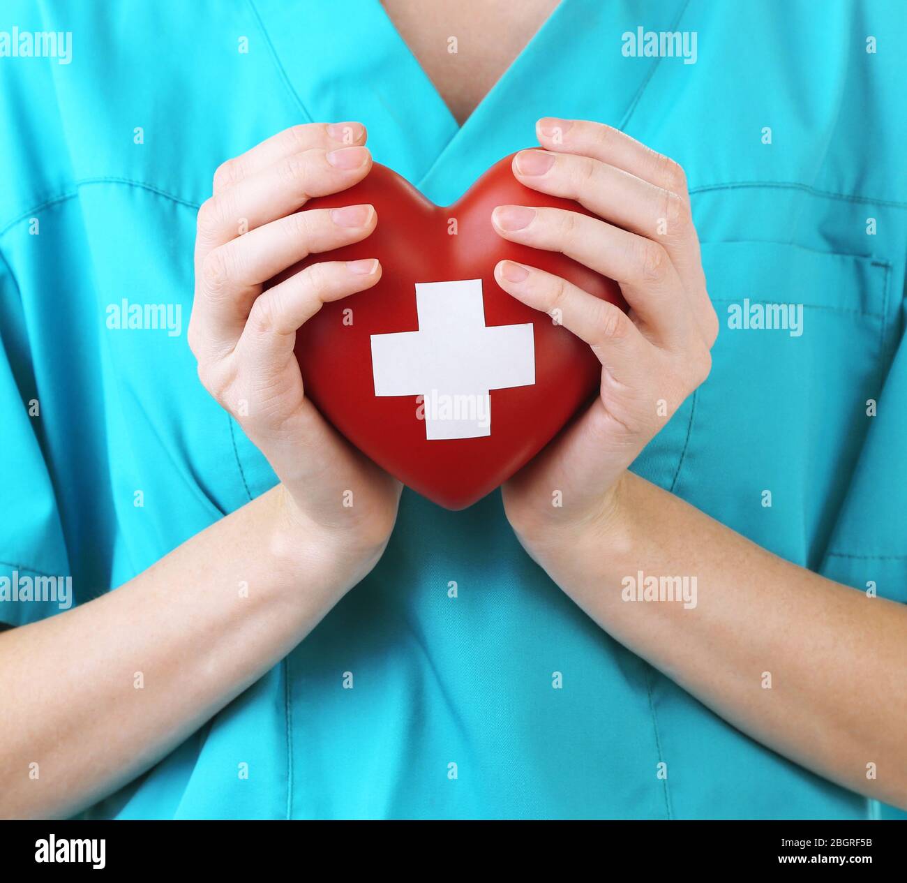 Red heart with cross sign in doctor hand, close-up, isolated on white ...