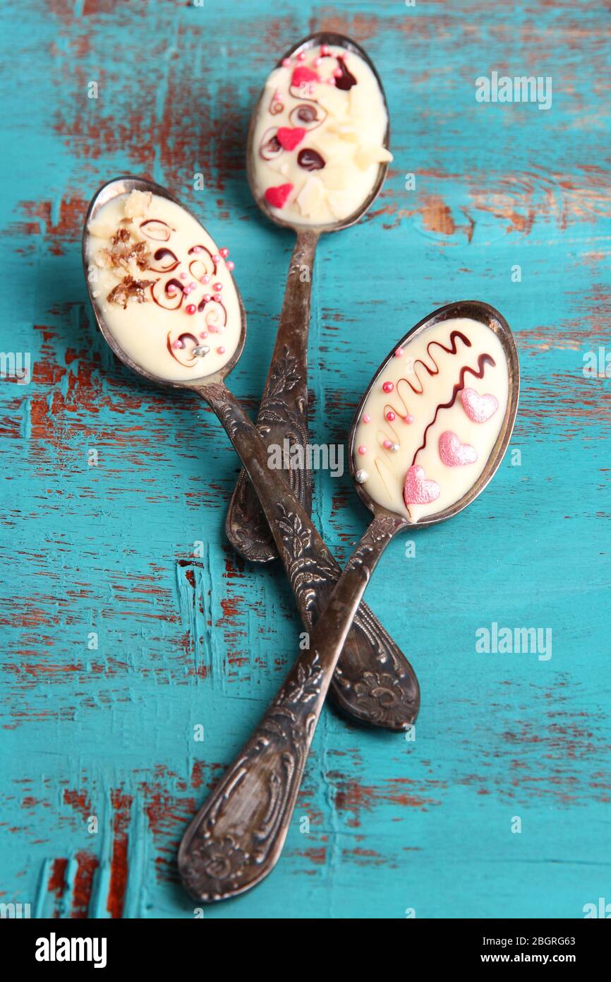 Spoons with tasty chocolate for party on old blue wooden table Stock ...