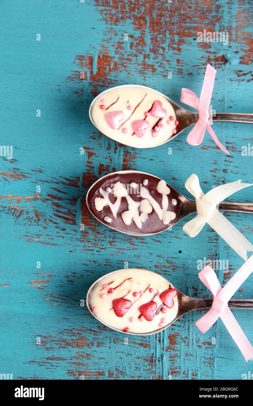 Spoons with tasty chocolate for party on old blue wooden table Stock ...