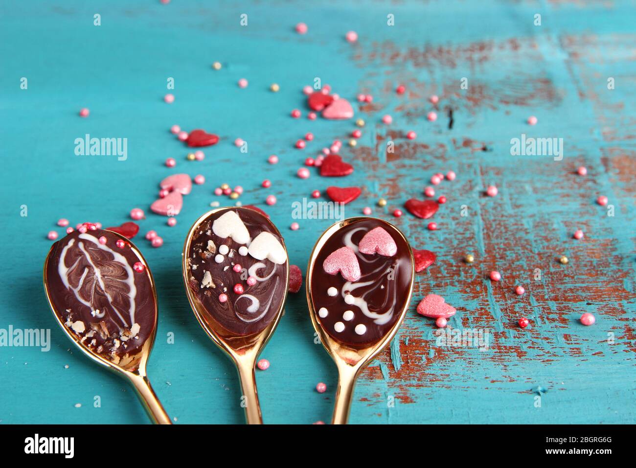 Spoons with tasty chocolate for party on old blue wooden table Stock ...