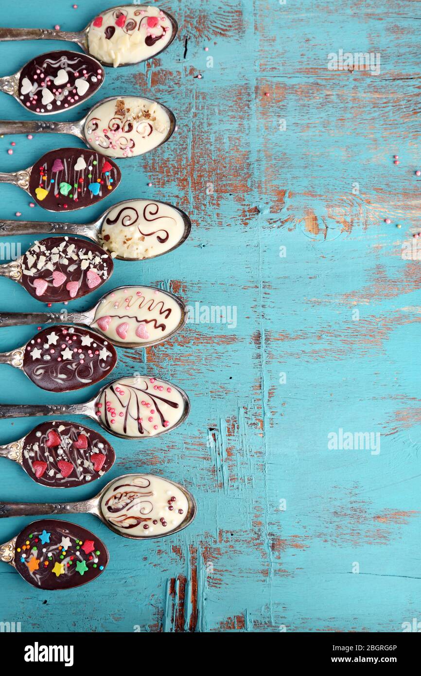 Spoons with tasty chocolate for party on old blue wooden table Stock ...