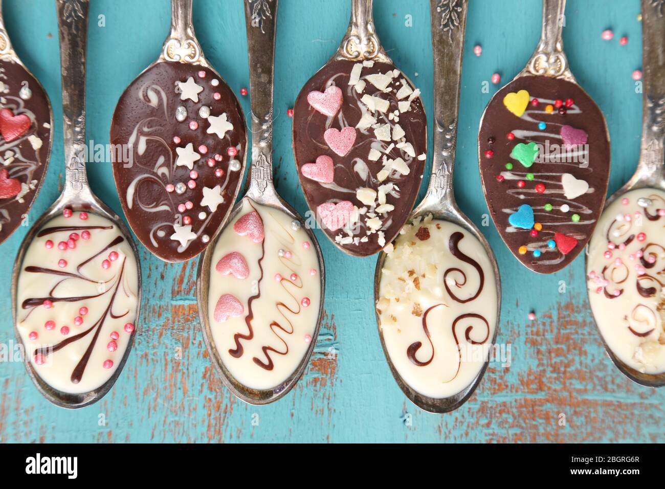 Spoons with tasty chocolate for party on old blue wooden table Stock ...
