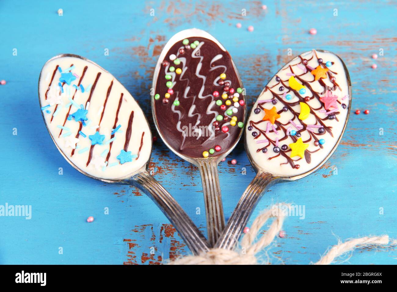 Spoons with tasty chocolate for party on old blue wooden table Stock ...