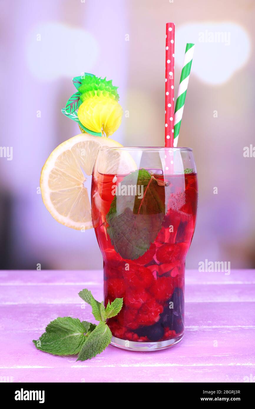Glass of cold berry cocktail with lemon on wooden table Stock Photo - Alamy