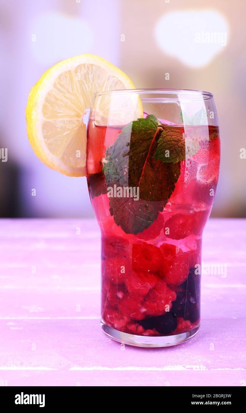 Glass of cold berry cocktail with lemon on wooden table Stock Photo - Alamy